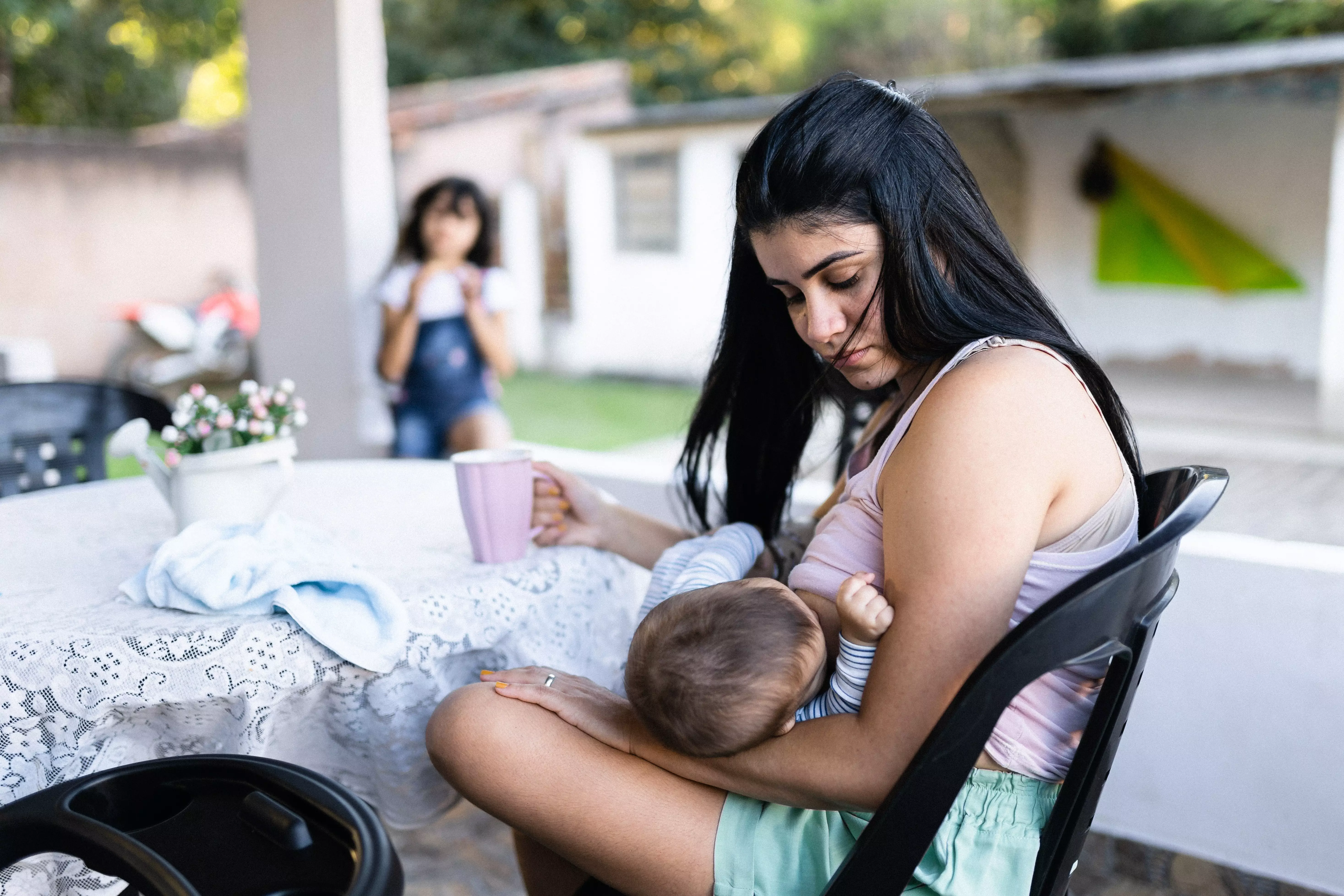 טרינקט קאַווע בשעת ברעסטפידינג אויף די צוריק דעק.