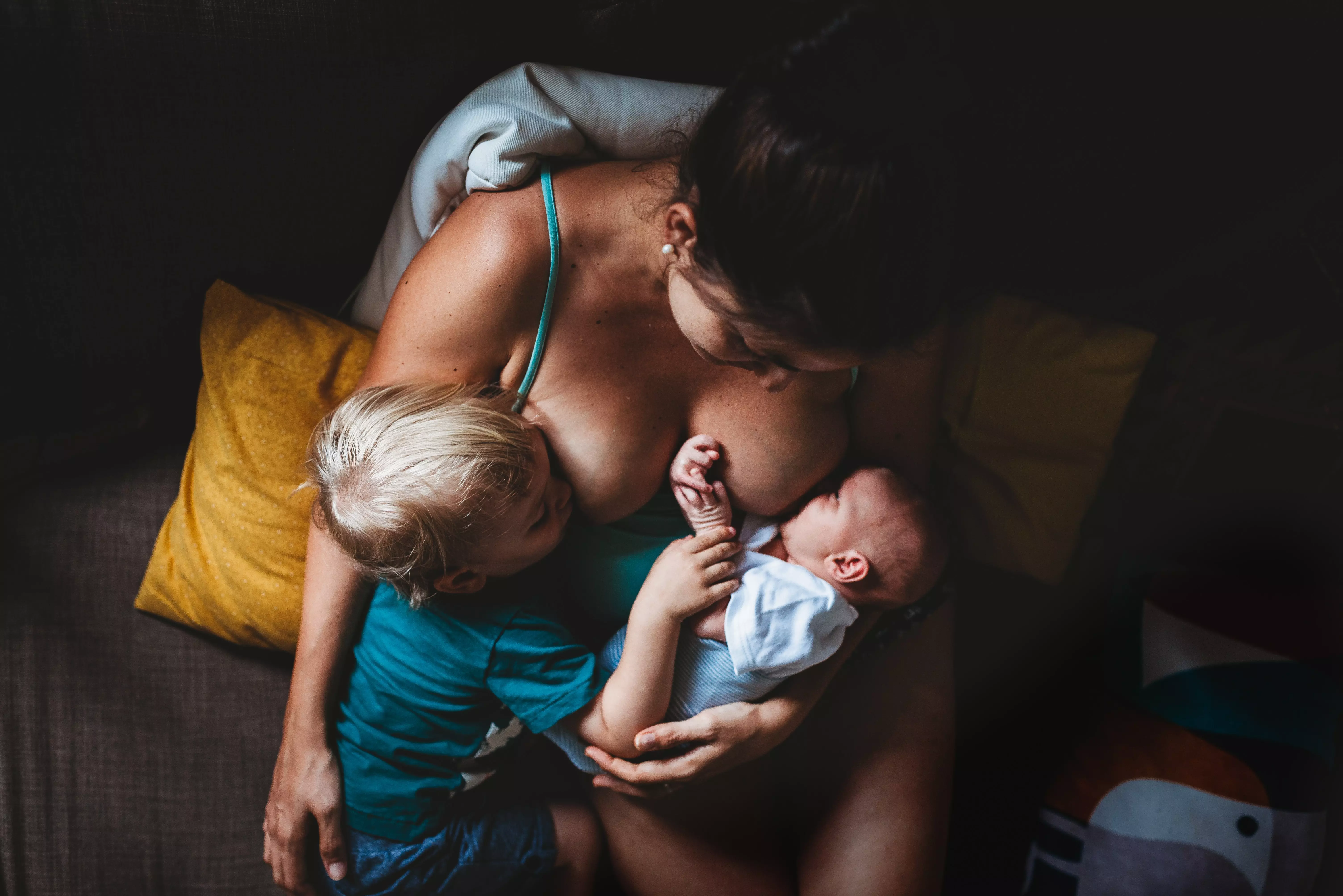 El tándem de madres amamanta a un niño pequeño y a un recién nacido en un artículo sobre si la lactancia materna puede causar contrac...