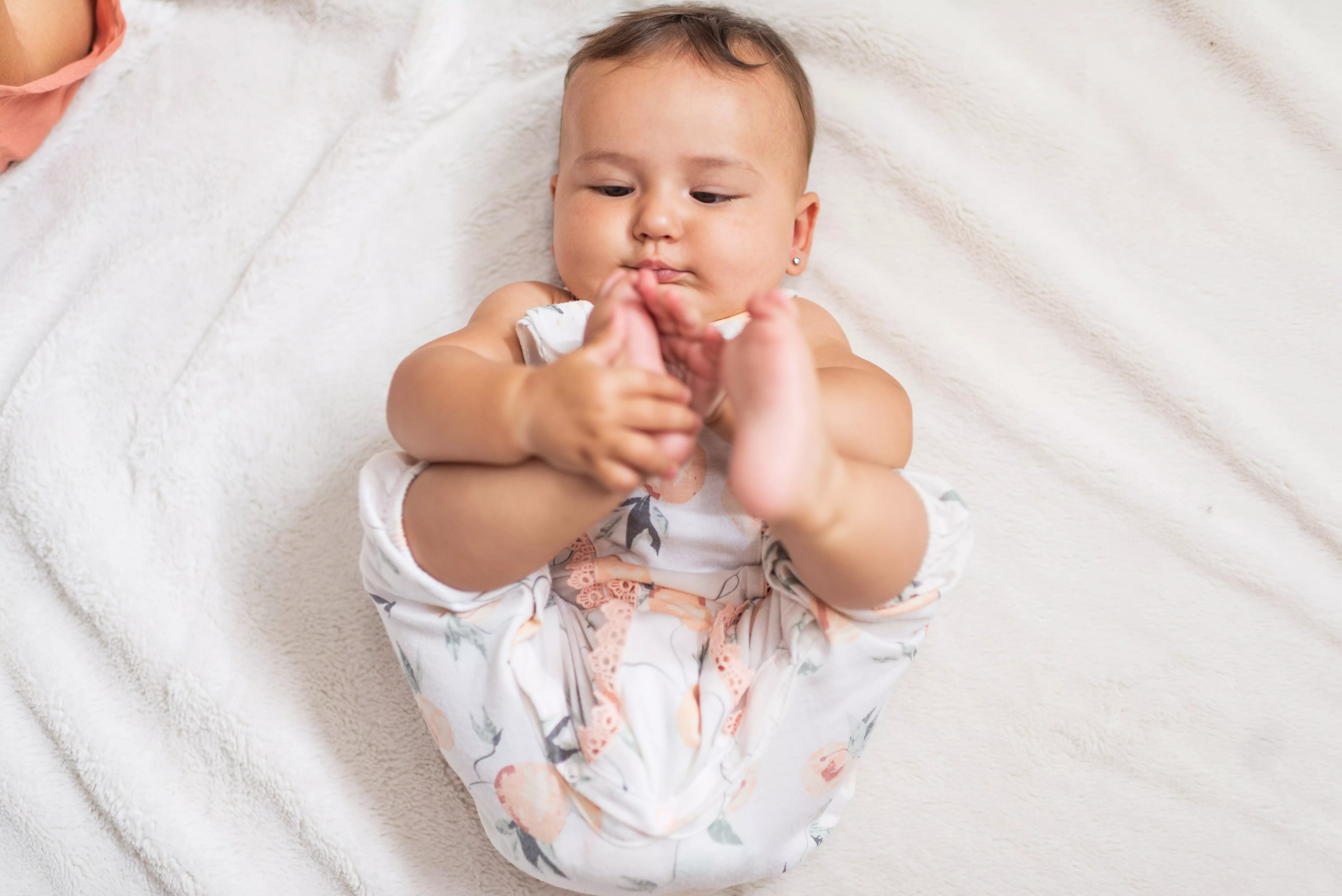 Bayi gembira bermain dengan jari kaki mereka, nama tengah pendek untuk perempuan