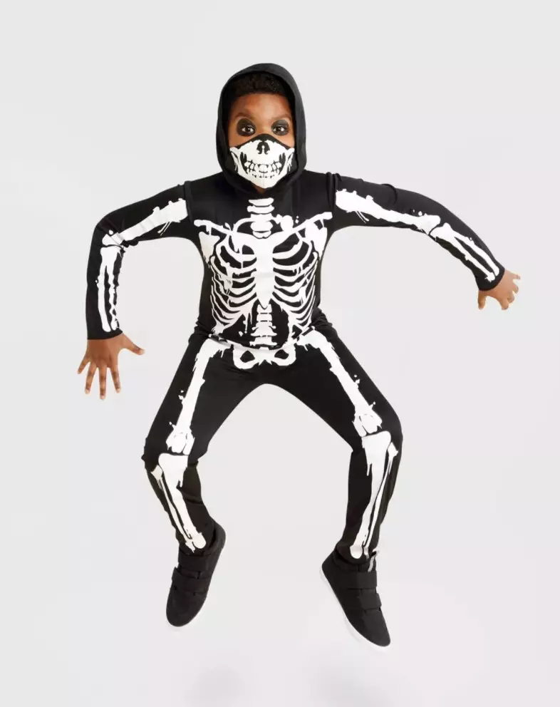 Batang lalaki na tumatalon, nakasuot ng skeleton costume