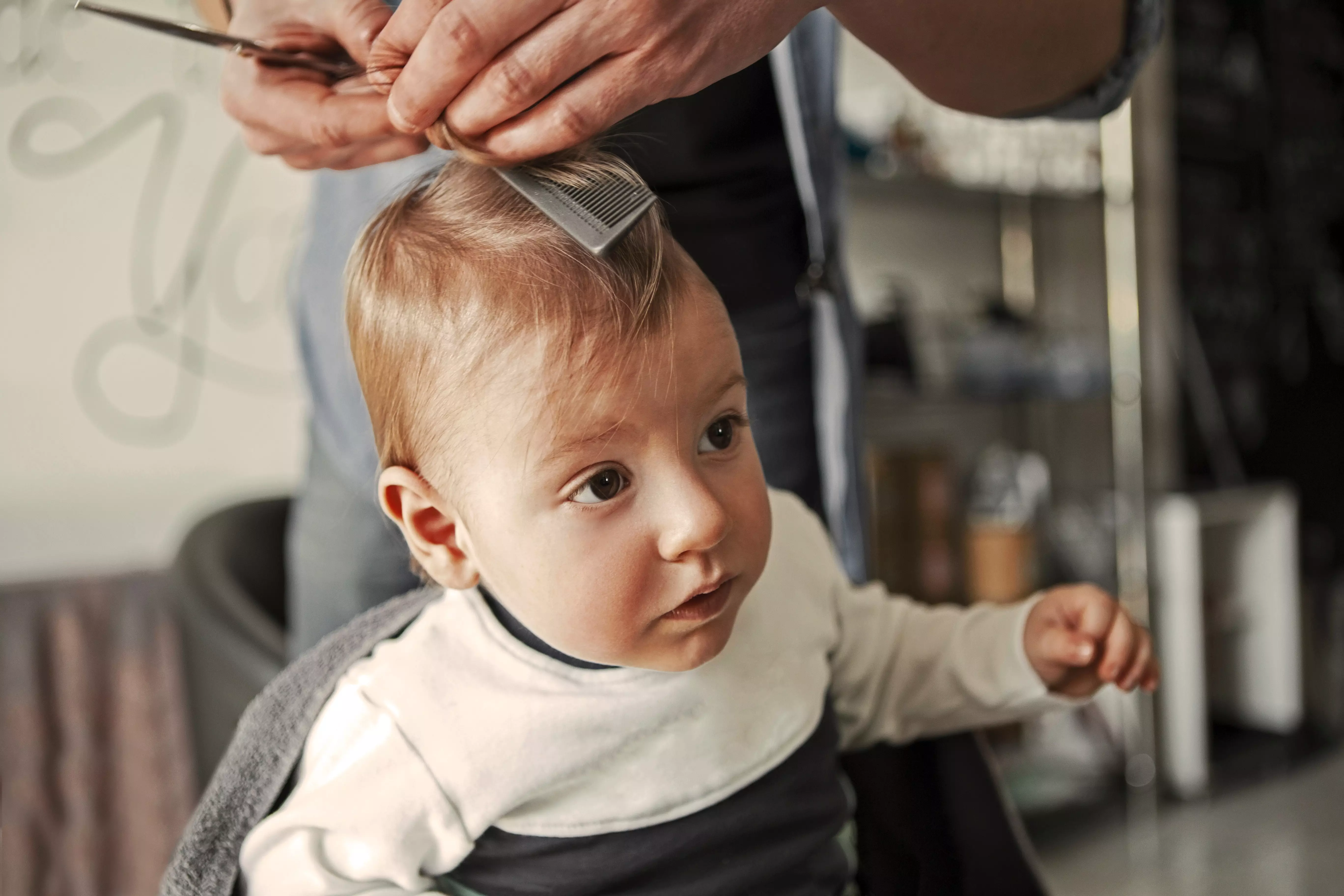 O bebé está facendo o seu primeiro corte de pelo na perruquería