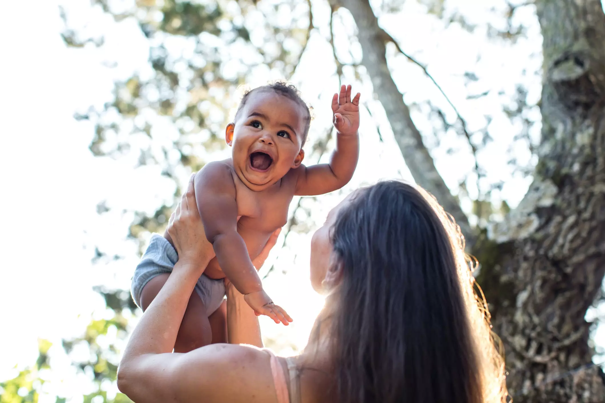 moeder houdt baby in de lucht